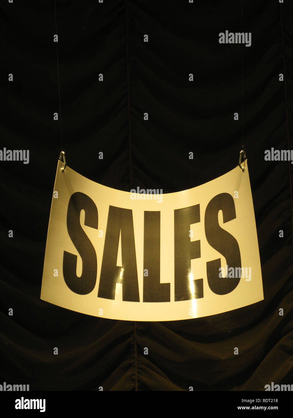 sales sign in shop window at night Stock Photo - Alamy