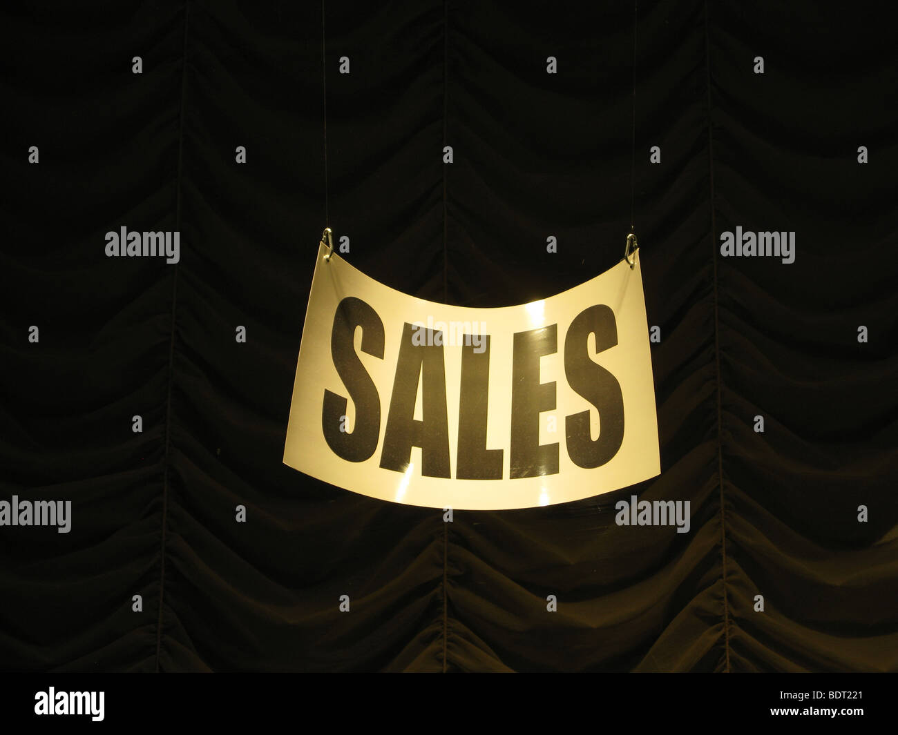sales sign in shop window at night Stock Photo - Alamy