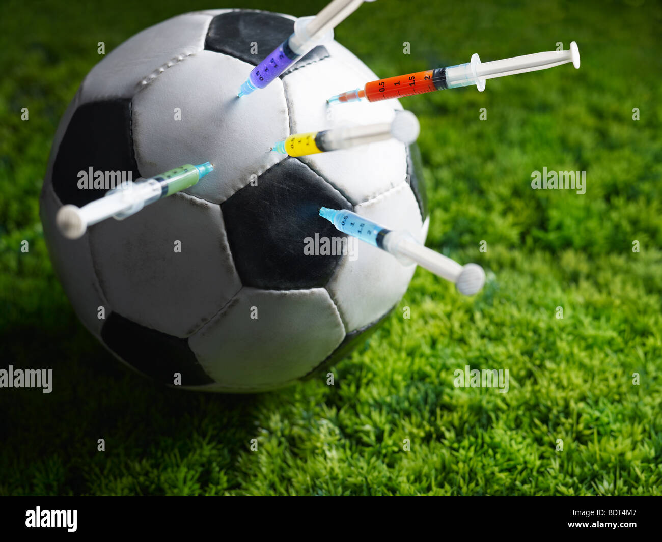 five syringes threaded in soccer ball. Copy space Stock Photo - Alamy
