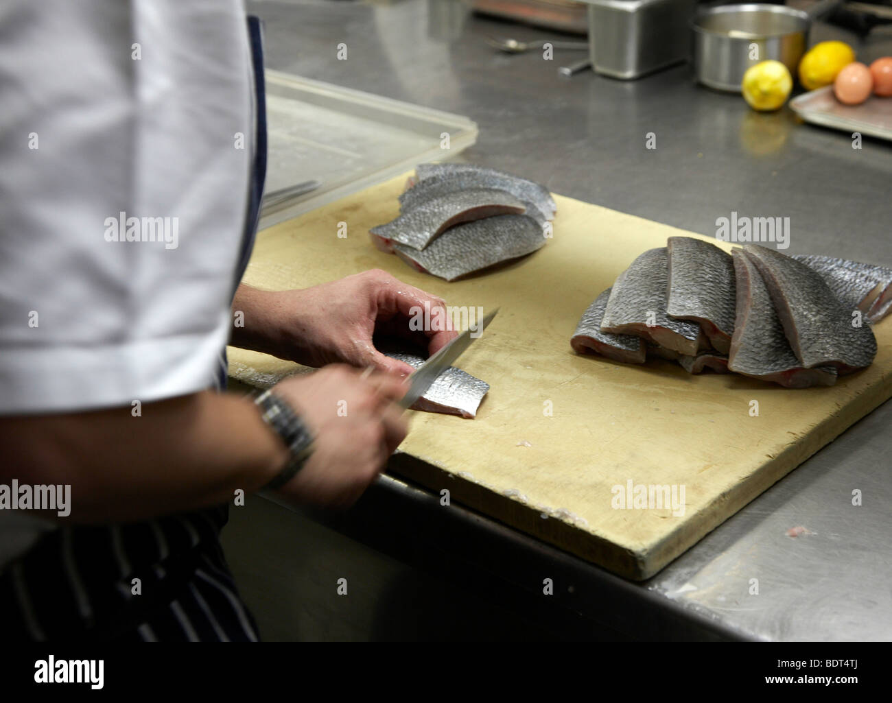 male chef slicing fish preparing it for lunch menu at Jason Atherton's ...