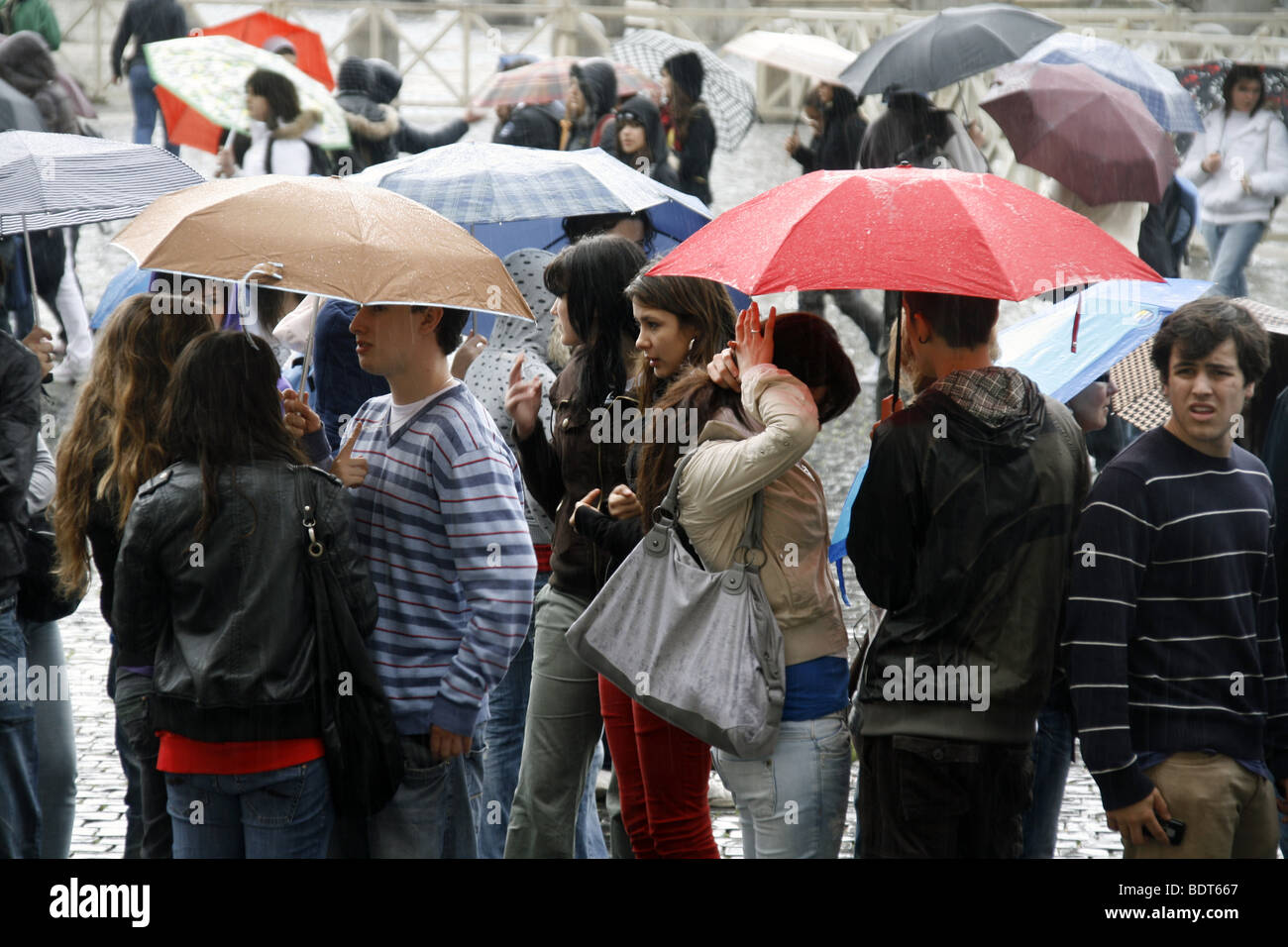 tourists in heavy rain in st peters square rome Stock Photo - Alamy
