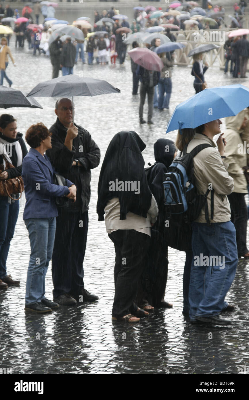tourists in heavy rain in st peters square rome Stock Photo - Alamy