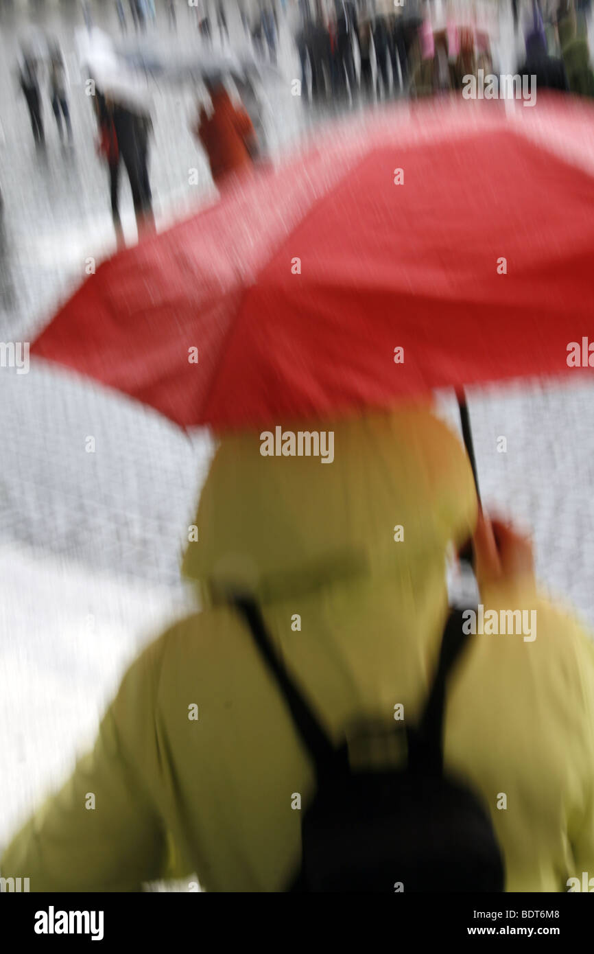 person with red umbrella in rain in city town Stock Photo - Alamy