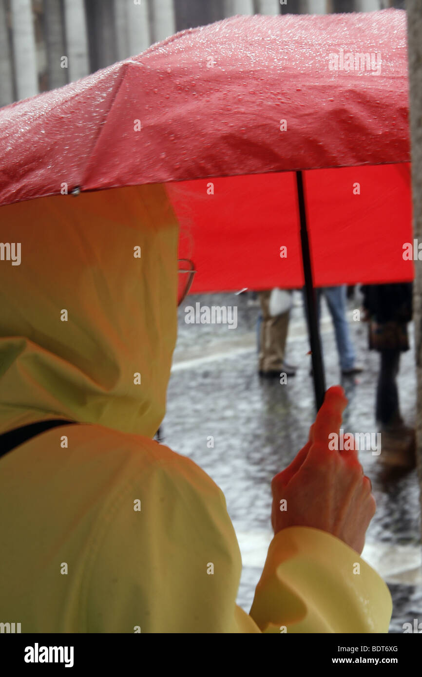 person with red umbrella in rain in city town Stock Photo - Alamy