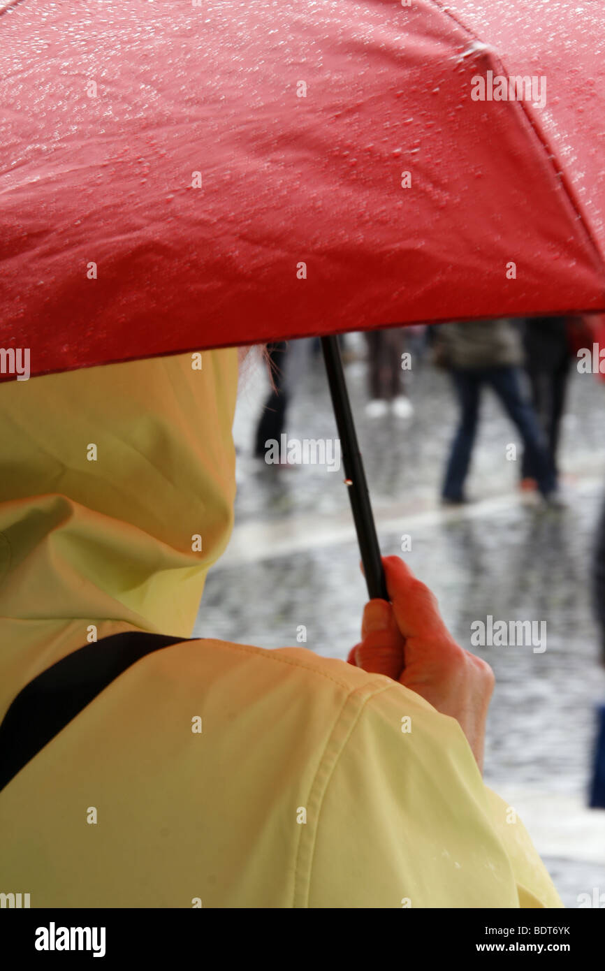person with red umbrella in rain in city town Stock Photo - Alamy
