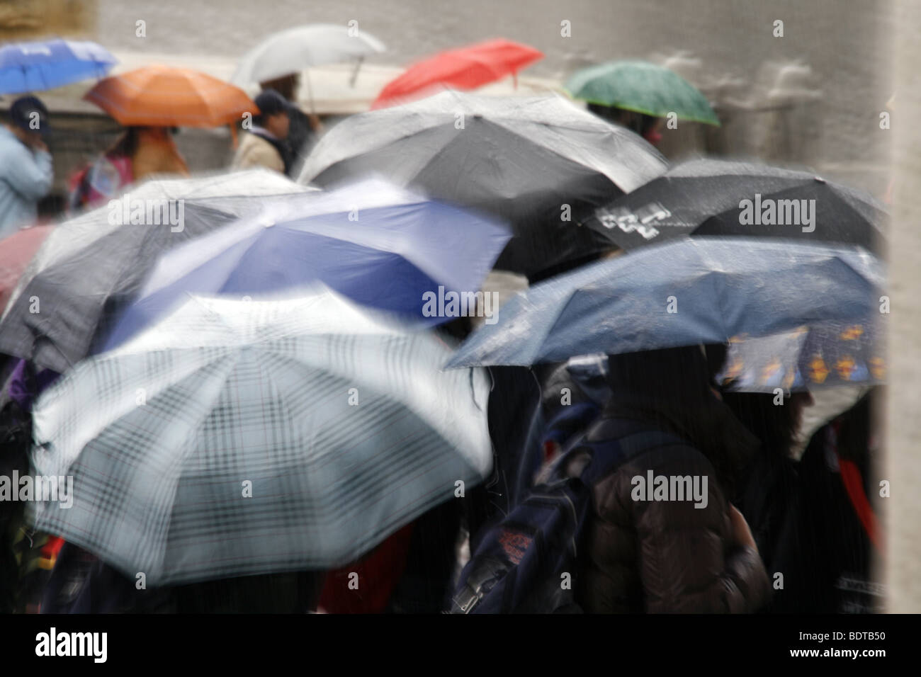 crowd of people with umbrellas in heavy rain in city town Stock Photo ...