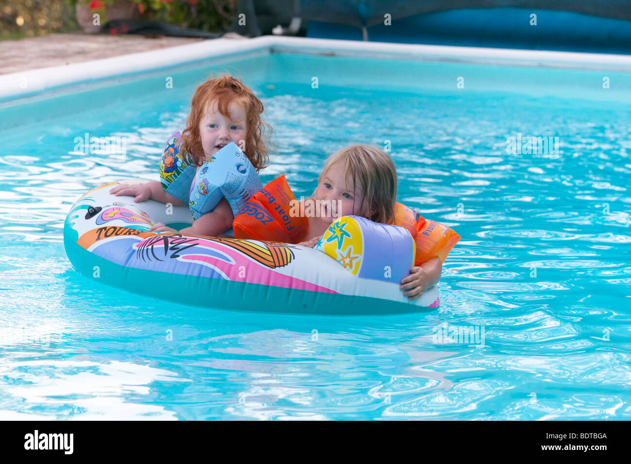 Two small girls in inflatable boat on swimming pool Stock Photo - Alamy