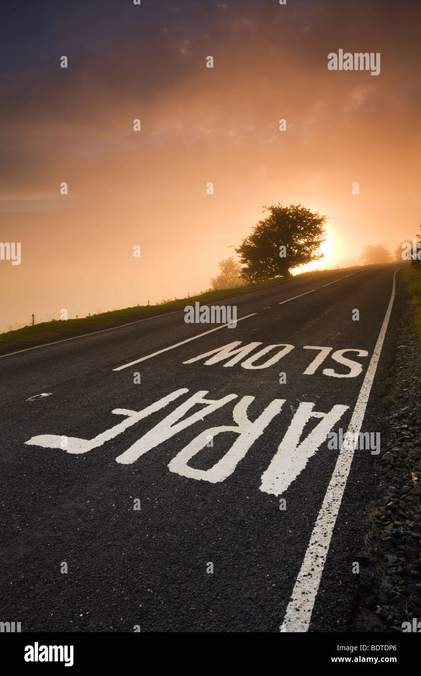 Painted road sign on a moorland road on a misty sunrise, Brecon Beacons ...