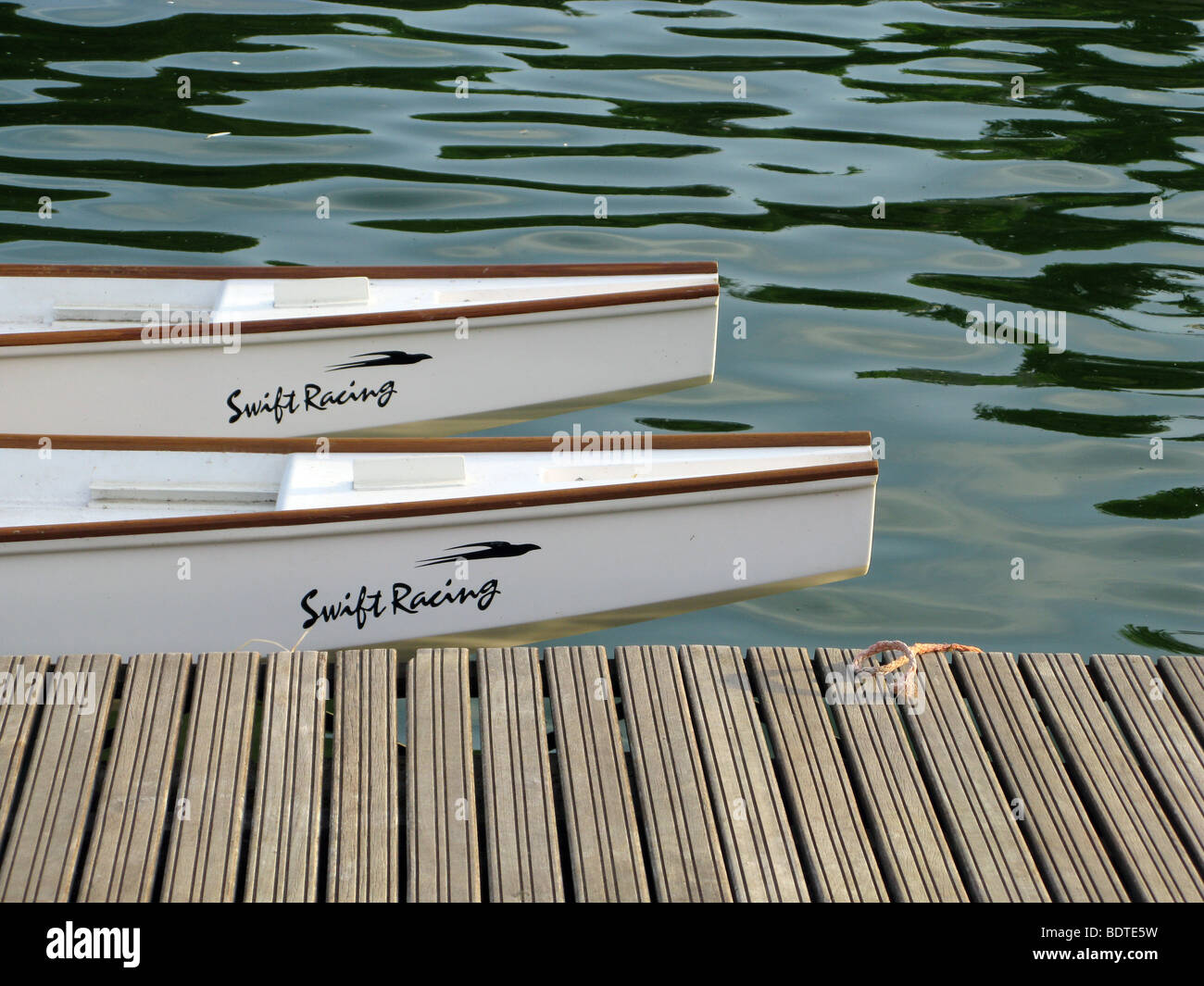 two racing boats by wooden jetty on lake in sun Stock Photo - Alamy