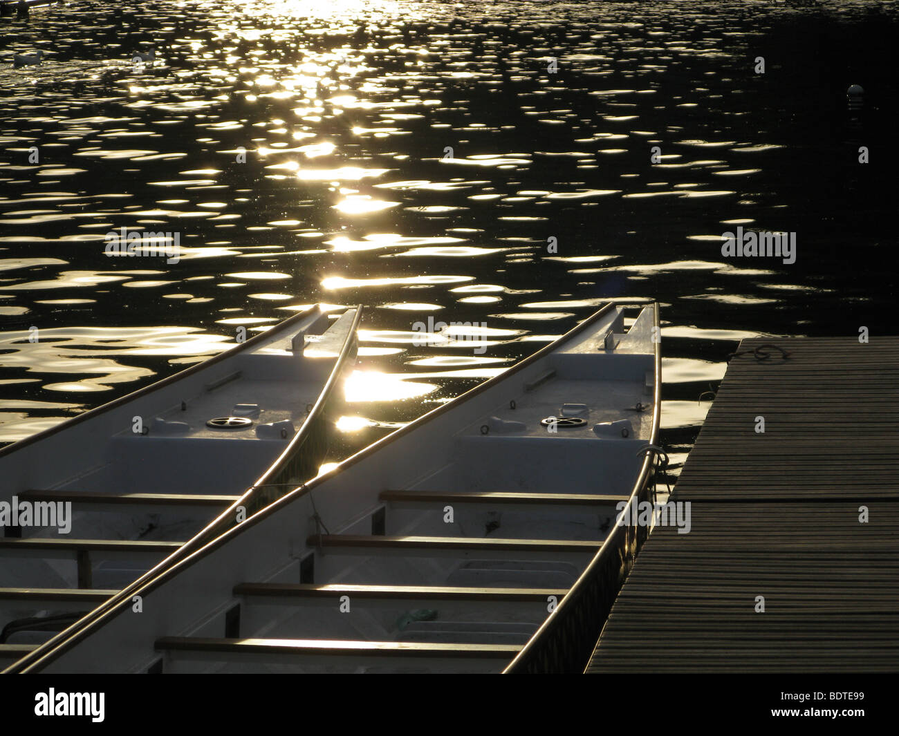 two racing boats by wooden jetty on lake in sun Stock Photo - Alamy