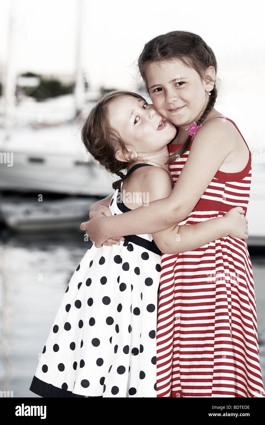 Two sisters embracing in the harbour Stock Photo - Alamy