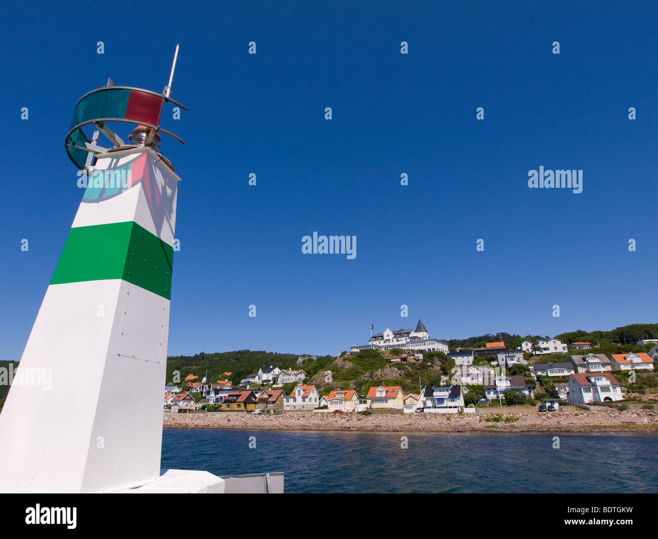A harbour lighthouse rises in front of the resort town of Molle, Sweden ...