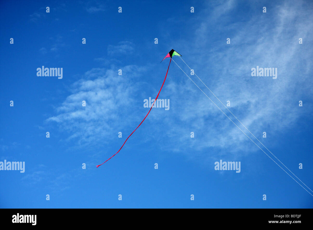 Colourful kite flying in blue sky Stock Photo - Alamy