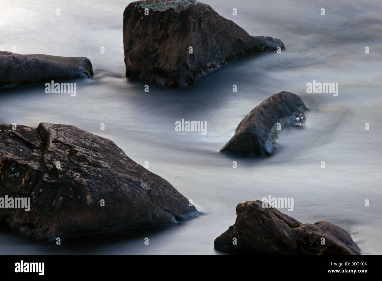 Fine Art. Water flowing around rocks and boulders Stock Photo - Alamy