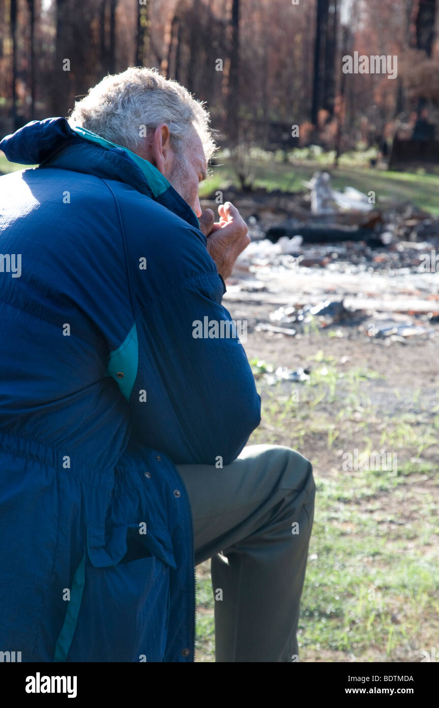 Man sitting surrounded by bushfire devastation, Australia Stock Photo ...