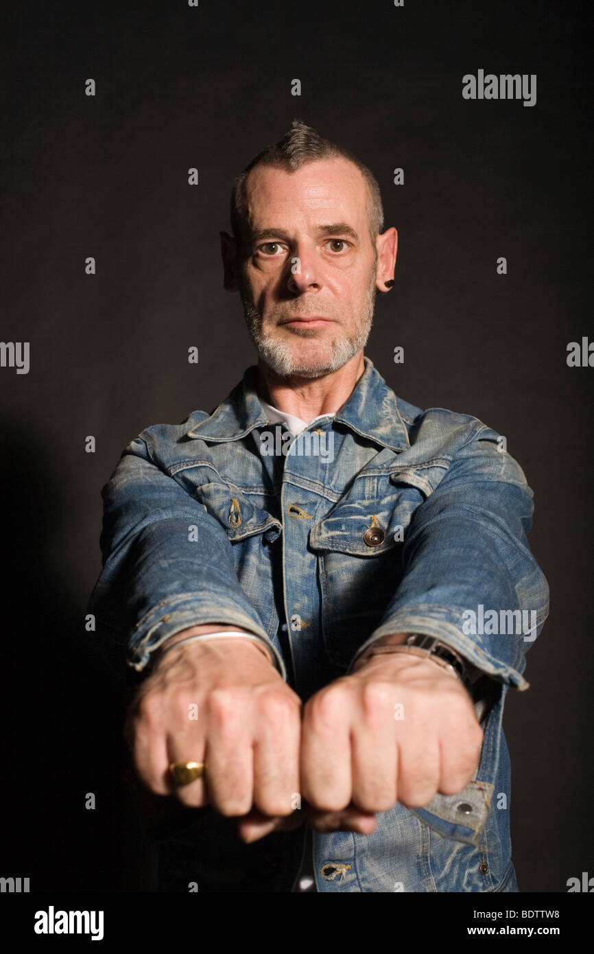 Alternative looking man with his fists in front of him in a powerful ...