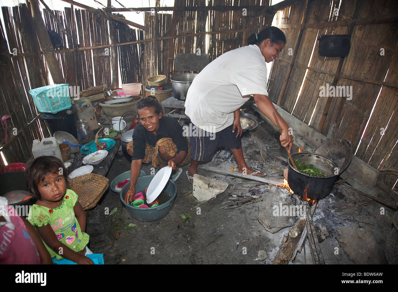 TIMOR LESTE Women cooking on open fire in traditional kitchen, Uma Ana ...