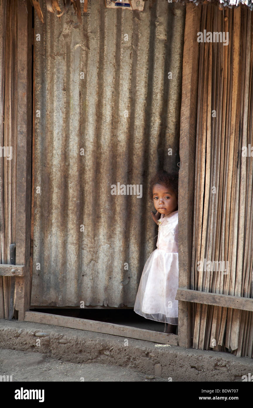 TIMOR LESTE Girl of Aosera, Julmira Anin, peeping out of the door of ...