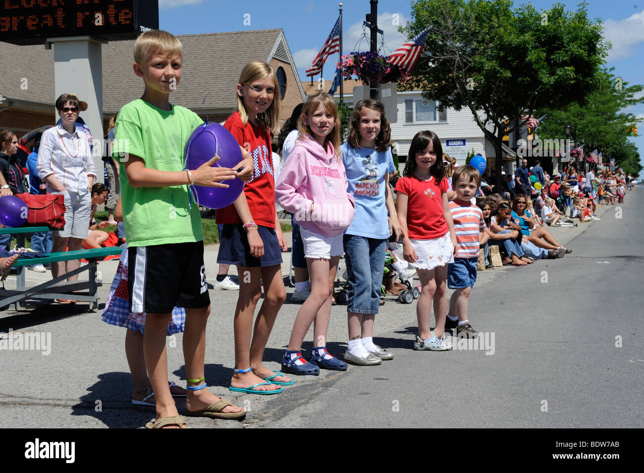 Kids line street watching patriotic parade Stock Photo - Alamy