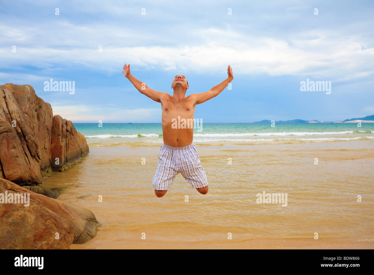 Young man jumping on the tropical beach Stock Photo - Alamy