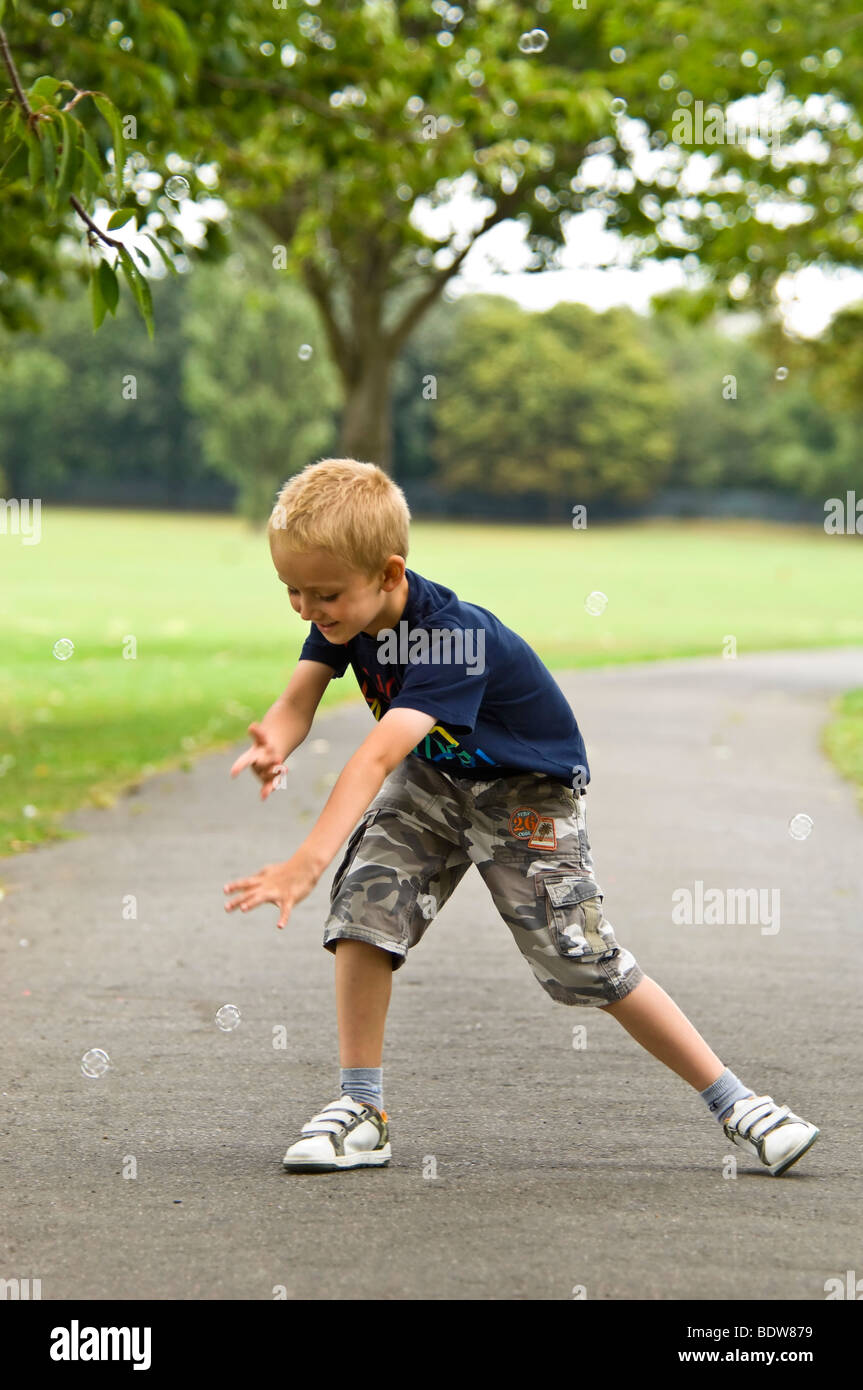 Vertical close up portrait of a young boy having great fun chasing ...