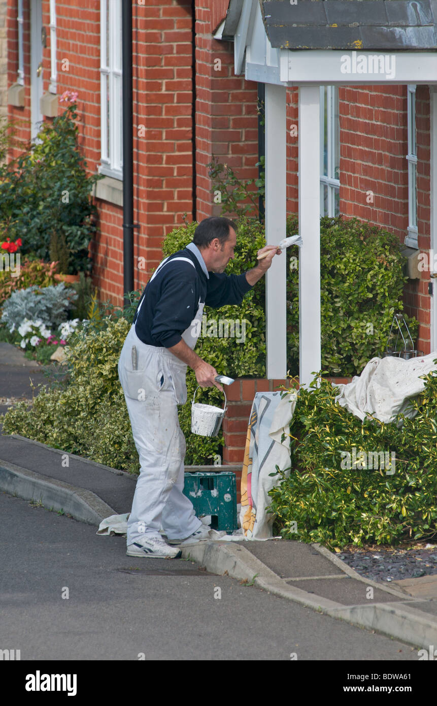 A painter and decorator at work painting a porch outside a house Stock ...