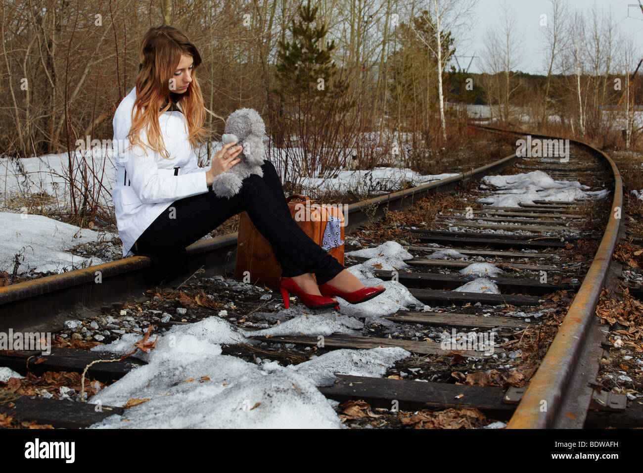 Blonde girl sitting on rail Stock Photo - Alamy