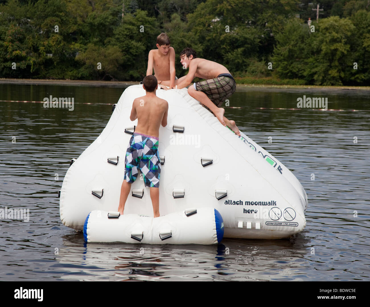 Boys climbing on a raft in a lake Stock Photo - Alamy