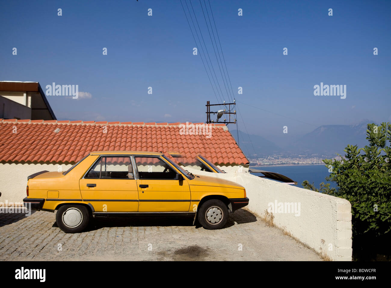 Vintage yellow crossover vehicle near old wall in street near sea in ...