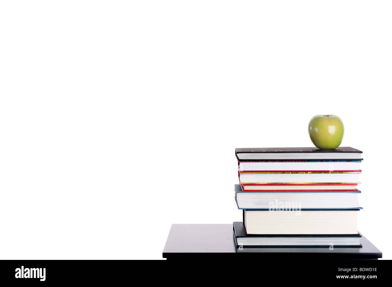 Horizontal image of a stack of books with a green apple on white Stock ...