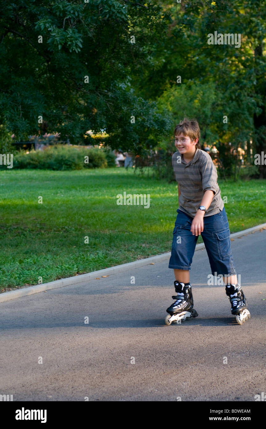 Young boy inline skating in park, smiling Stock Photo - Alamy