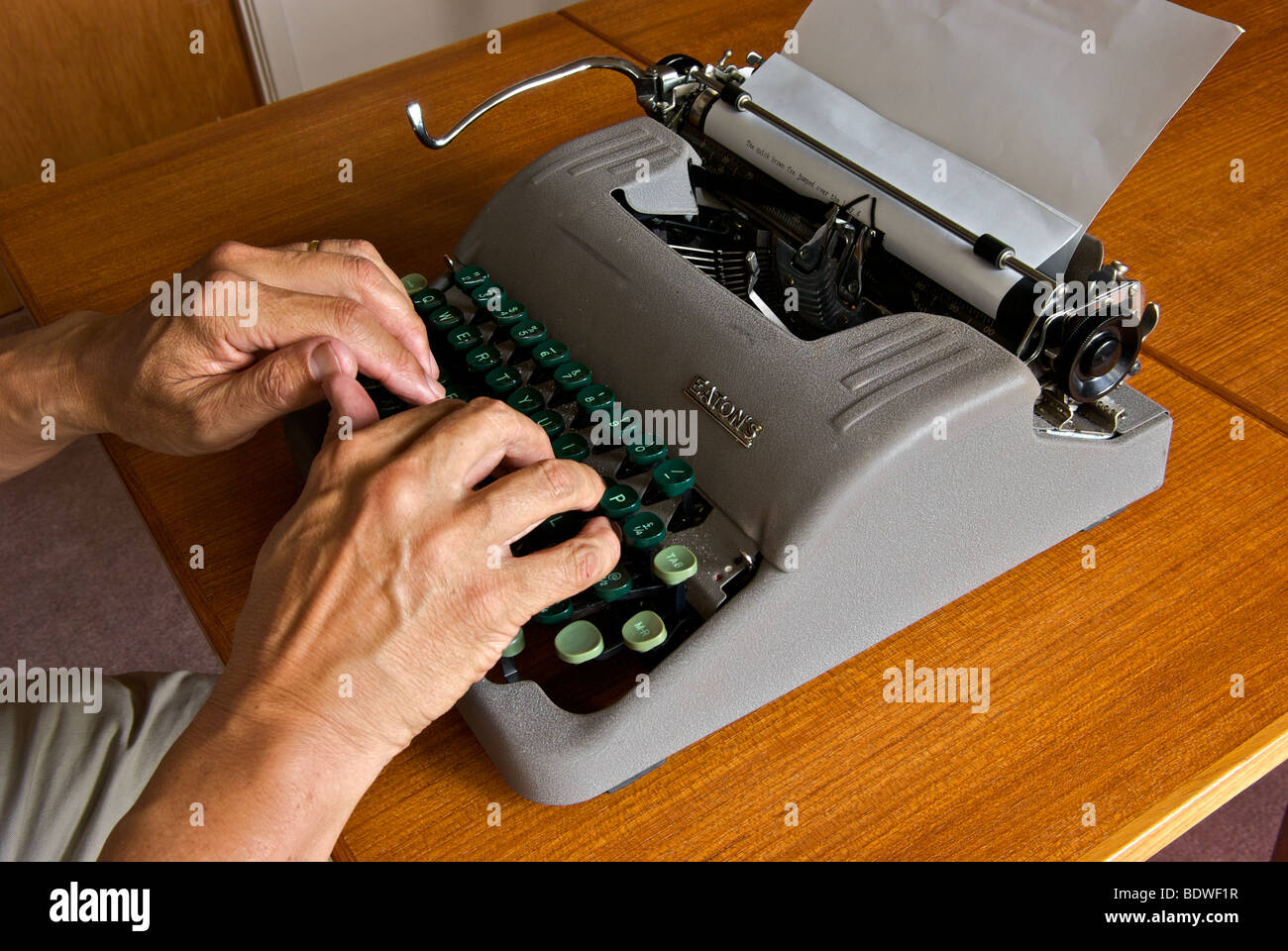 Outdated technology manual portable typewriter finger pushing on key in ...