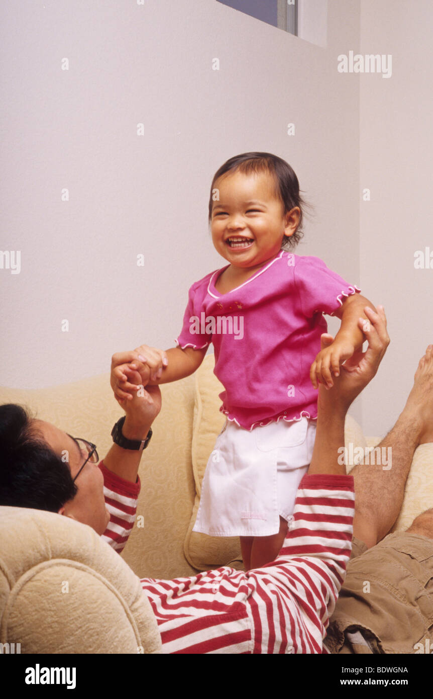 Japanese-American dad plays with daughter making her laugh and giggle ...