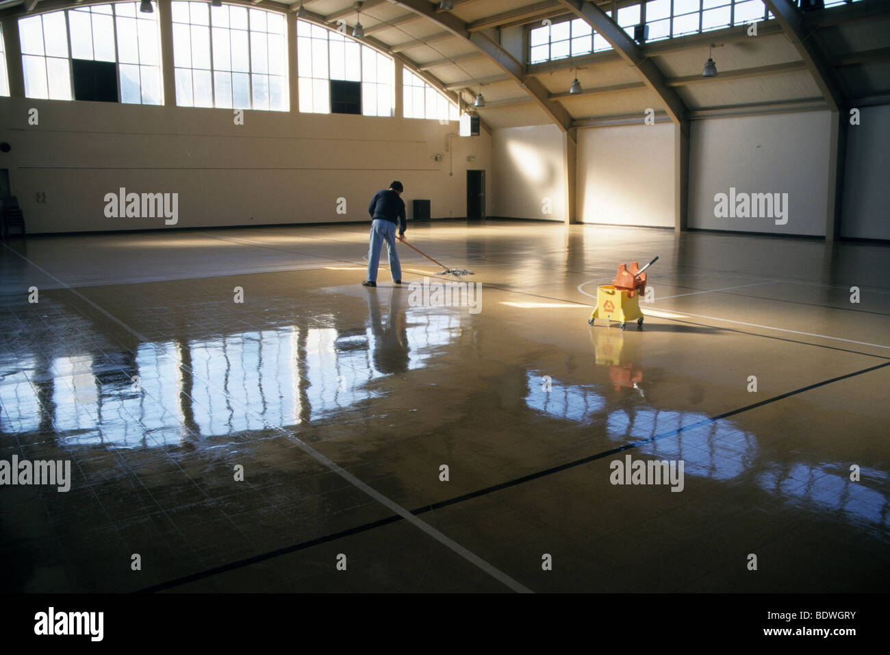 custodian maintenance man washed gymnasium athletic center surface ...