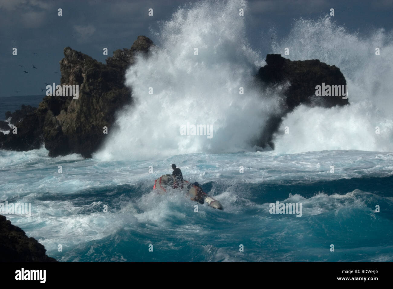Small boat and waves crashing over St. Peter and St. Paul's rocks ...