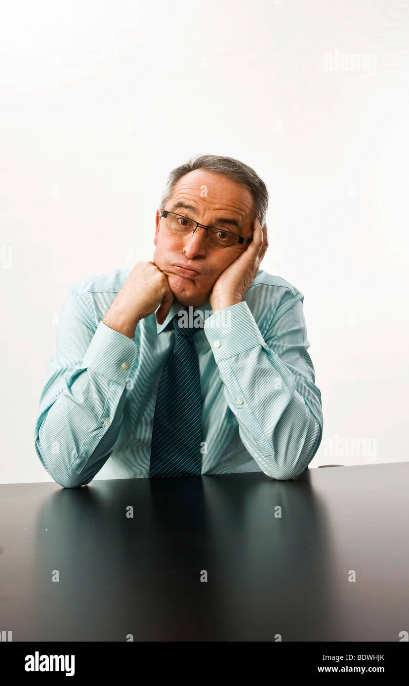 Tired manager with glasses sitting at his desk Stock Photo - Alamy