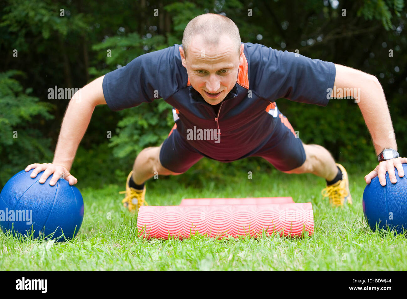 A man doing push-ups with medicine balls Stock Photo - Alamy
