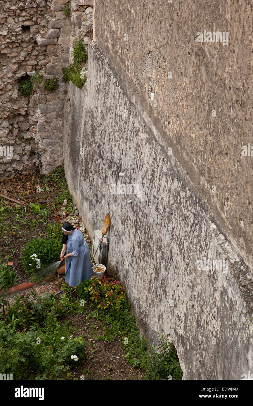 A nun watering a vegetable and flower patch in an enclosed garden in Dubrovnik Stock Photo - Alamy