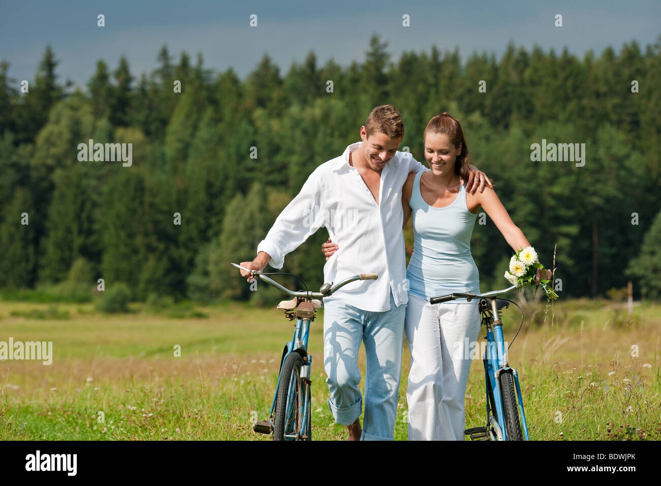 Romantic couple walking in meadow with old bike Stock Photo - Alamy