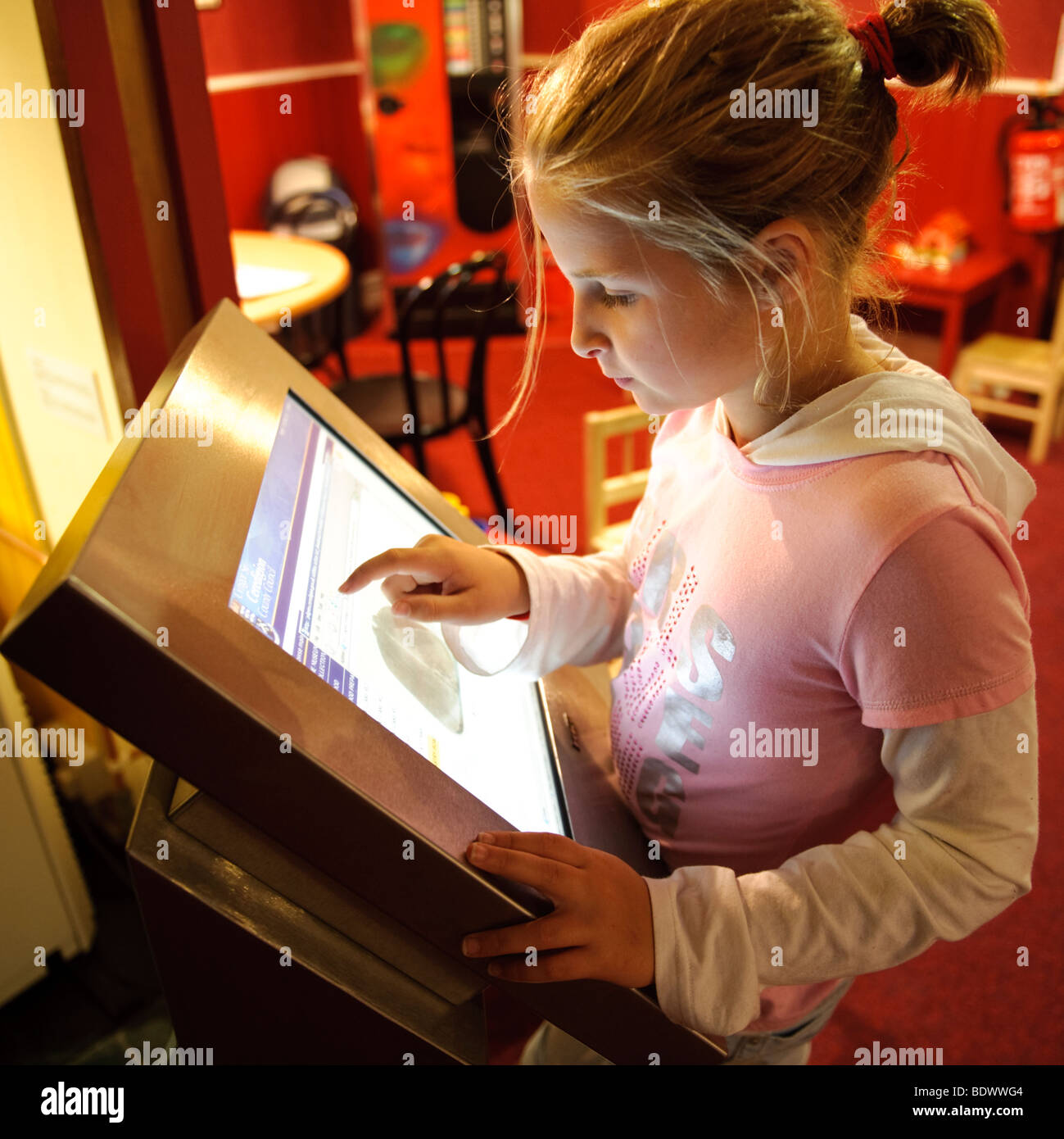 A ten year old girl child using a touch screen panel computer ...