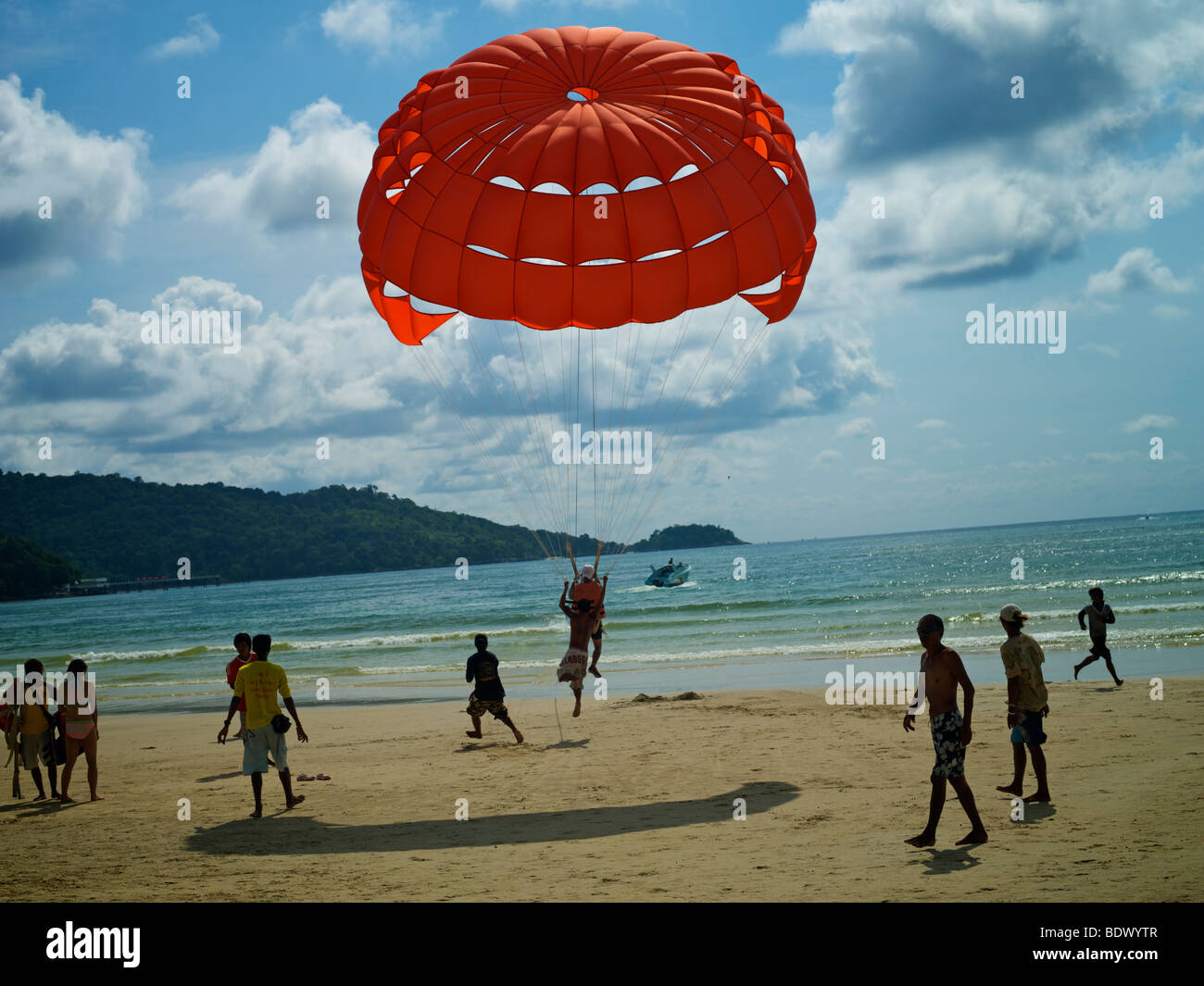 Tourist takes to the sky with the aid of a paragliding parachute pulled ...