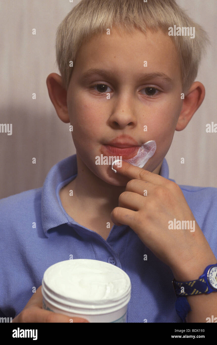 boy rubbing cream on chapped mouth and lips Stock Photo - Alamy
