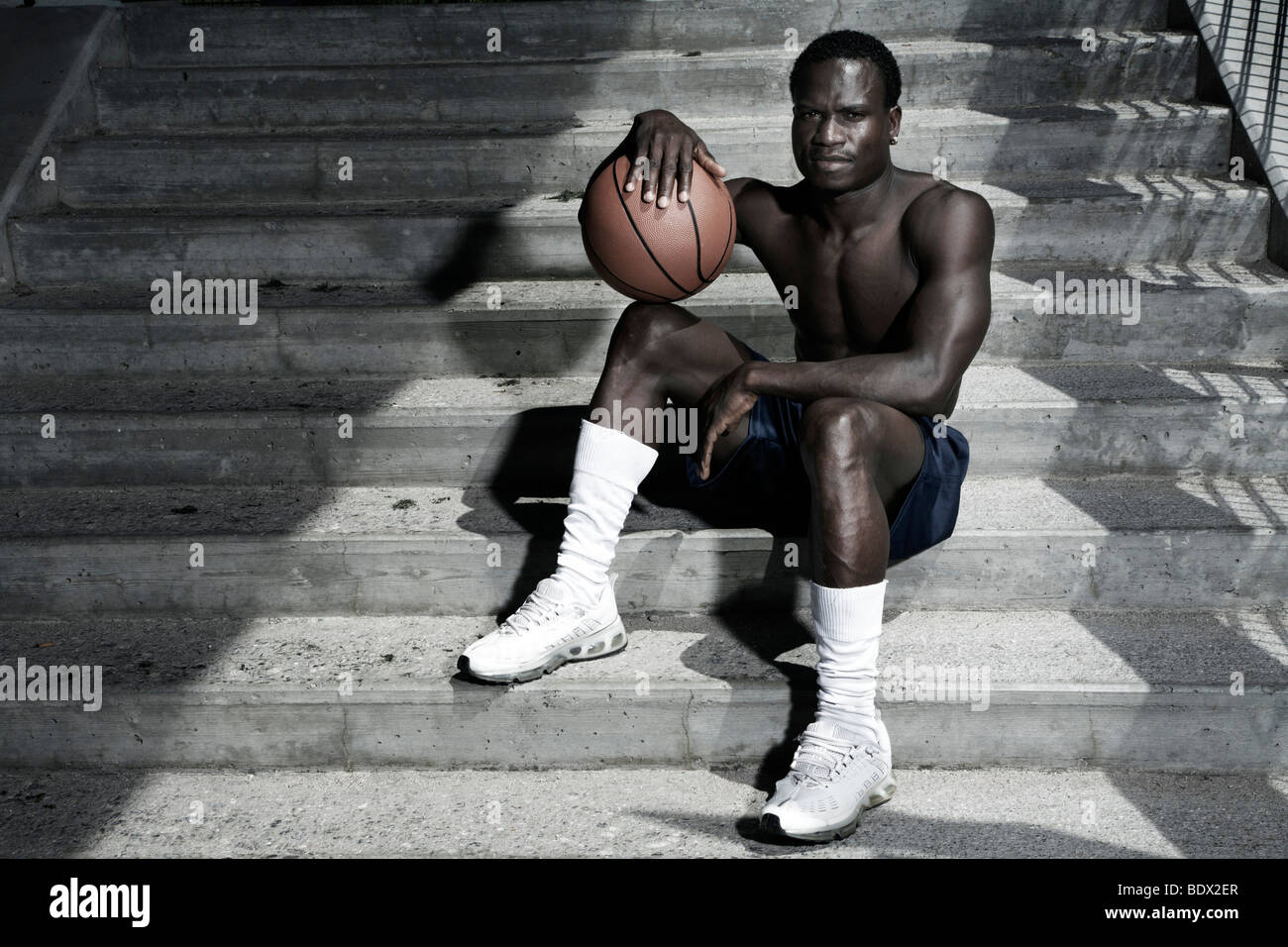 Young dark-skinned basketball player sitting on stairs, portrait Stock ...