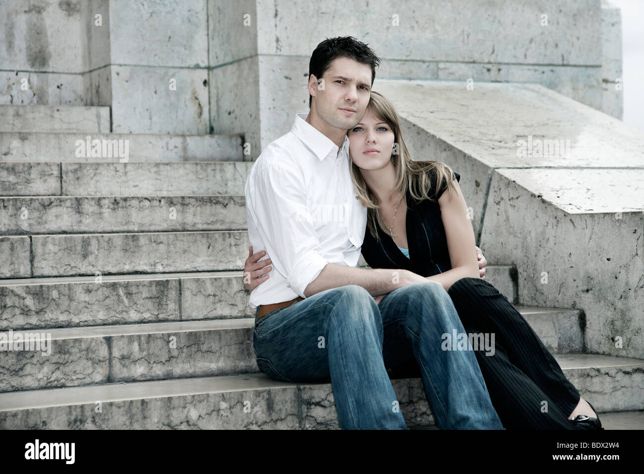 Young couple sitting on stairs, portrait Stock Photo - Alamy