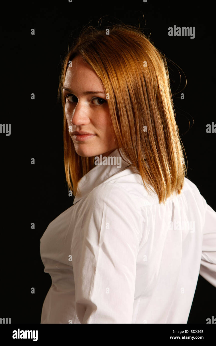 Young girl in white shirt looking over her shoulder to the camera Stock ...
