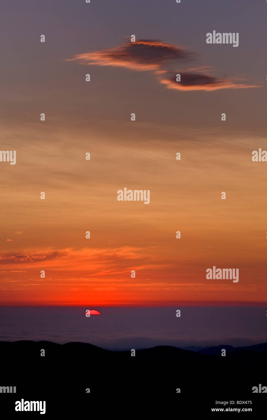 A fiery red sun melts into a sea of fog sitting above California's ...