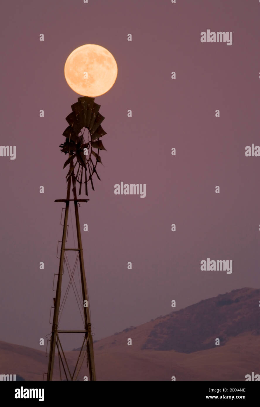A full September moon rising appears to balancing on top of an old ...