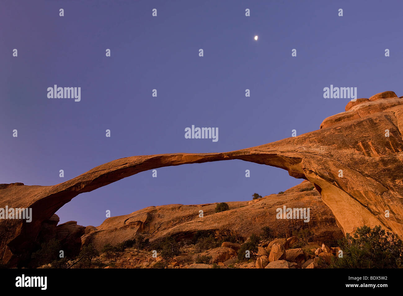 A setting half moon over Landscape Arch in early dawn light, Arches ...