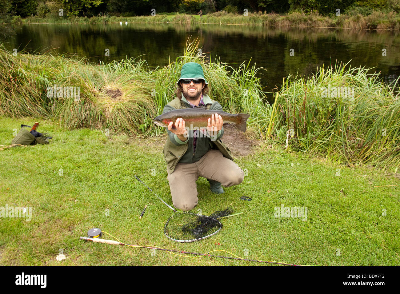 Trout fly fisherman with a large 6lb rainbow trout, Avington Fishery ...