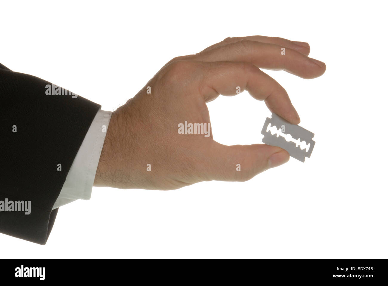 Business man with a razor blade between his fingers, a symbolic image ...
